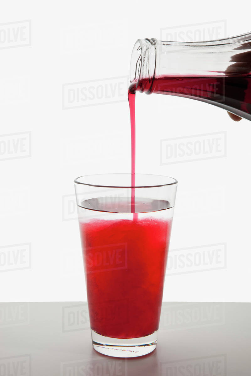 Detail of fruit syrup being poured into a glass of water - Stock Photo ...