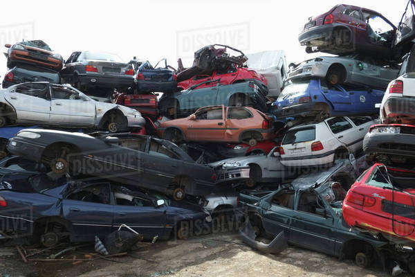 Cars stacked in scrap yard - Stock Photo - Dissolve