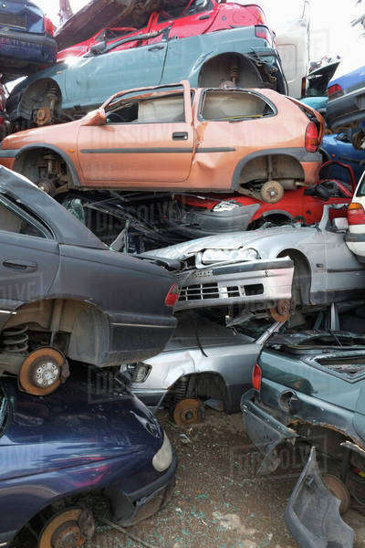 Cars stacked in scrap yard - Stock Photo - Dissolve
