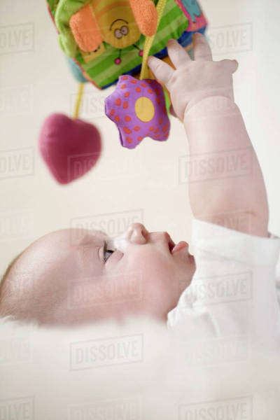A baby reaching up to touch a mobile - Royalty-free Stock Photo | Dissolve