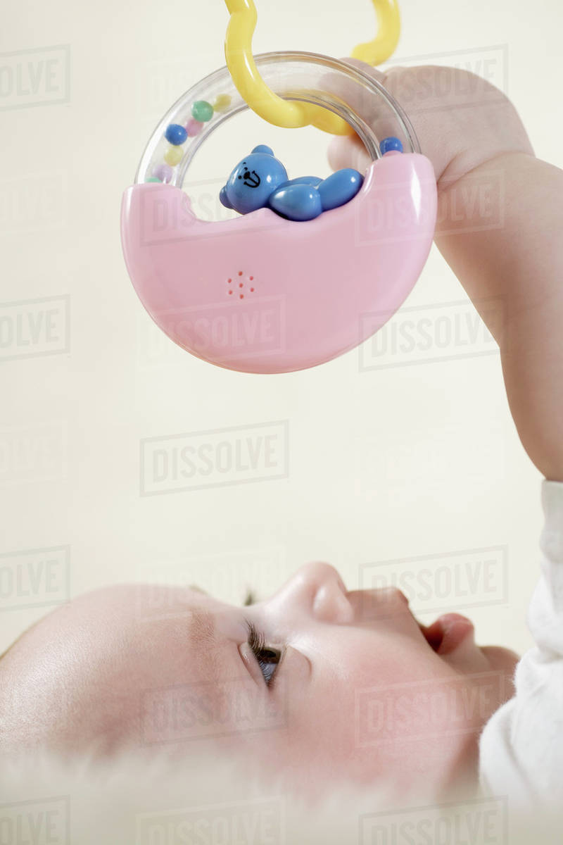 A baby reaching up to touch a mobile - Stock Photo - Dissolve