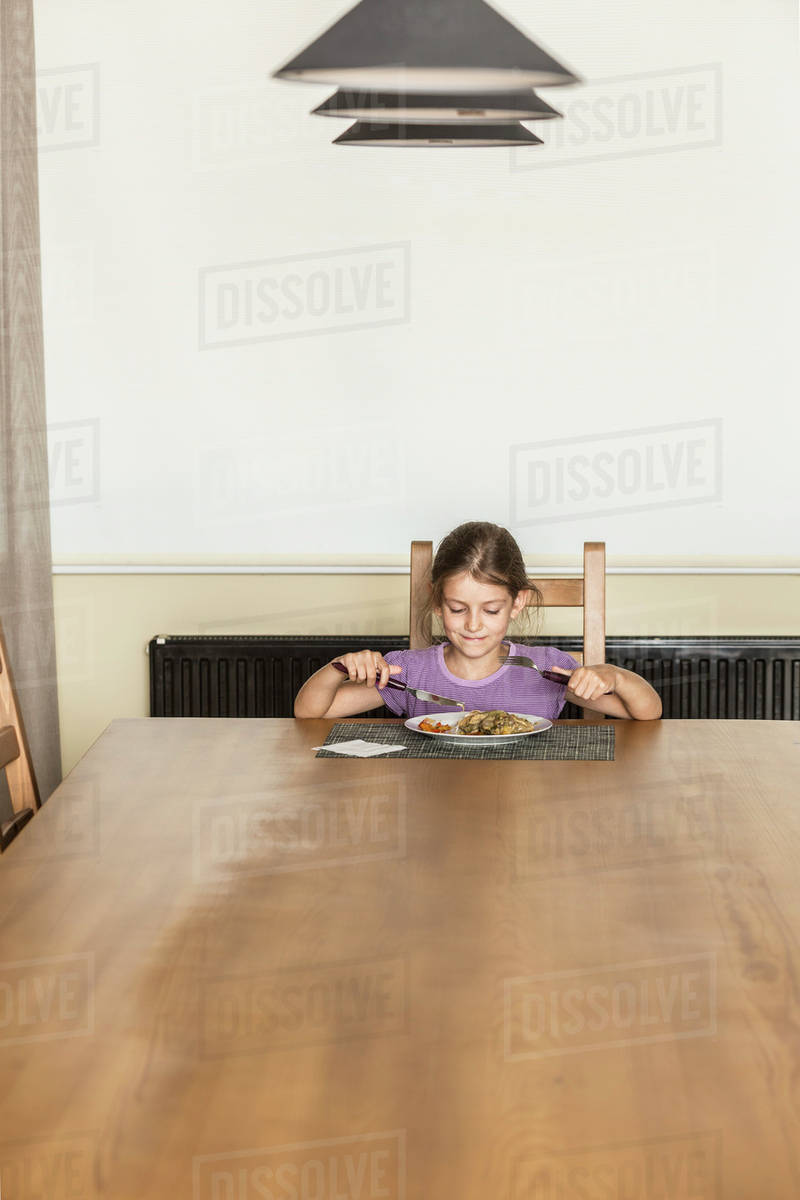 Girl having food at dining table in house - Royalty-free Stock Photo ...
