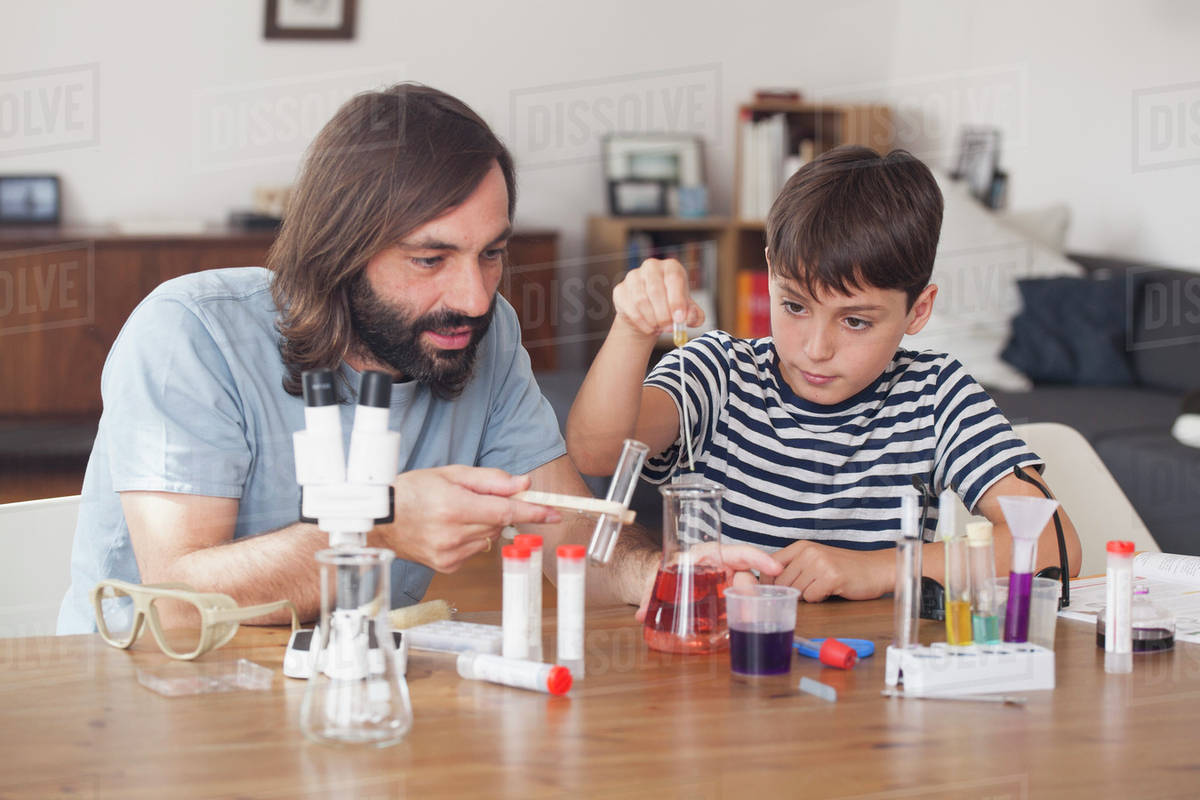 Father and son working on science experiment at home - Royalty-free ...