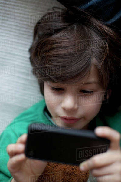 Boy playing with mobile phone - Stock Photo - Dissolve