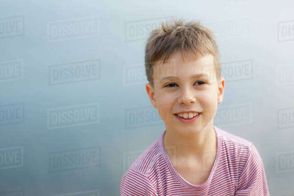 Thoughtful boy smiling while looking away outdoors - Royalty-free Stock ...
