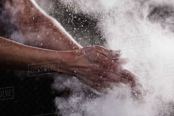 Cropped image of woman's hand dusting chalk powder for exercising ...