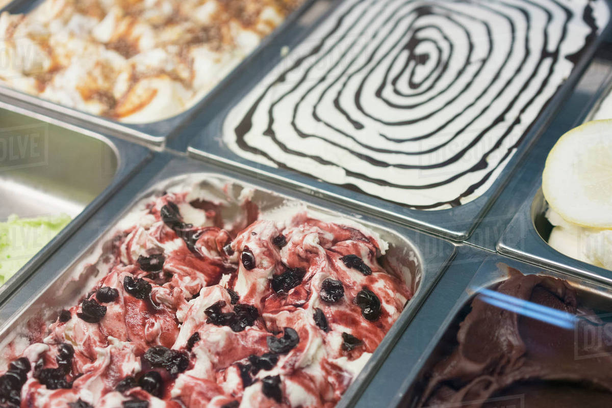 Various ice creams in containers on display at store - Royalty-free ...