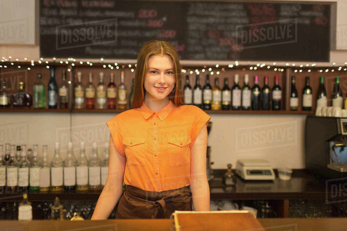 Portrait of smiling woman standing at bar counter - Royalty-free Stock ...