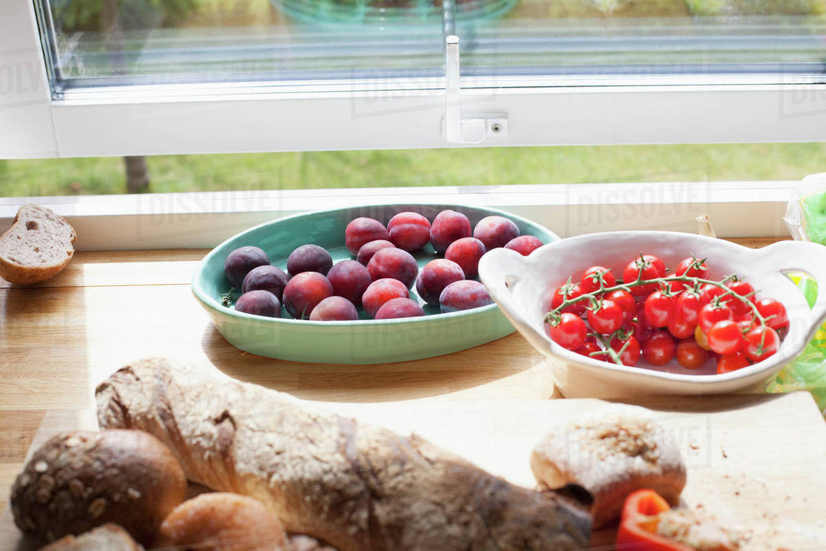 Close-up of fruits and bread on table by window - Royalty-free Stock ...