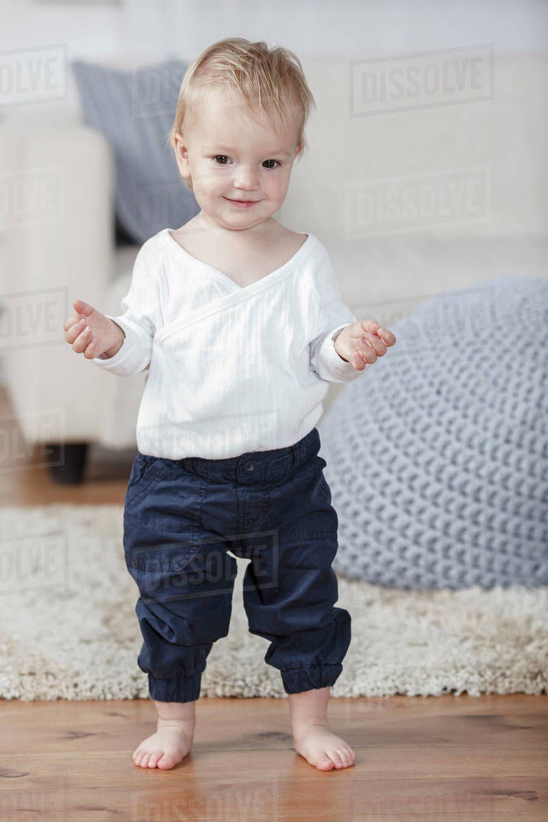 Full length of cute baby girl standing at home - Stock Photo - Dissolve