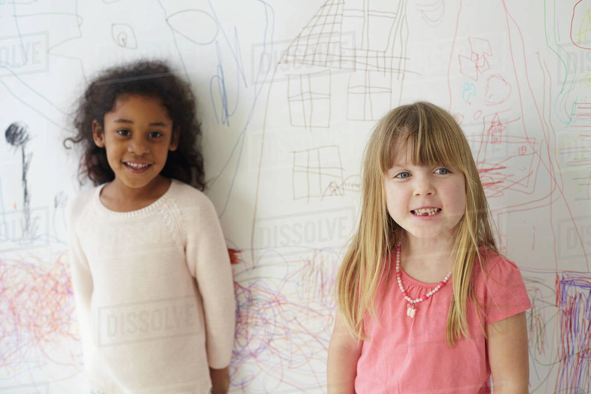 Portrait of girls standing against drawing on wall - Royalty-free Stock ...