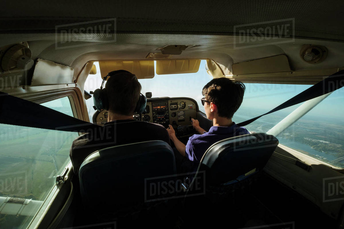 Father and son flying small airplane - Stock Photo - Dissolve