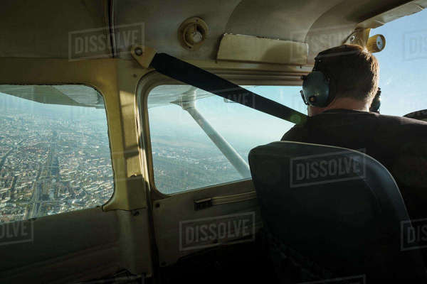 Man flying small airplane over city - Royalty-free Stock Photo | Dissolve