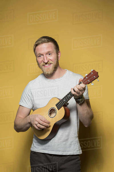 Portrait smiling man playing ukulele - Royalty-free Stock Photo | Dissolve