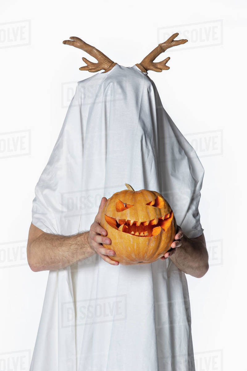 Portrait playful man in sheet costume holding jack o lantern - Royalty ...