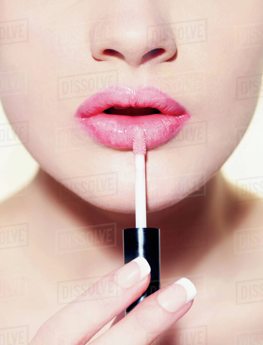 Close up woman applying lip gloss - Royalty-free Stock Photo | Dissolve