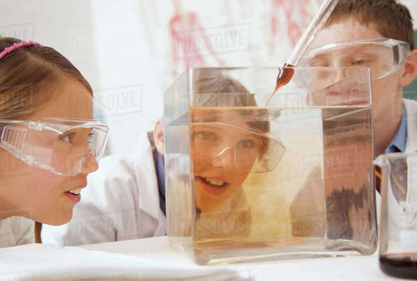 Junior high school students conducting scientific experiment in ...
