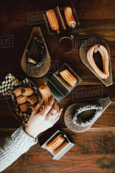 Woman eating assortment of churros - Royalty-free Stock Photo | Dissolve