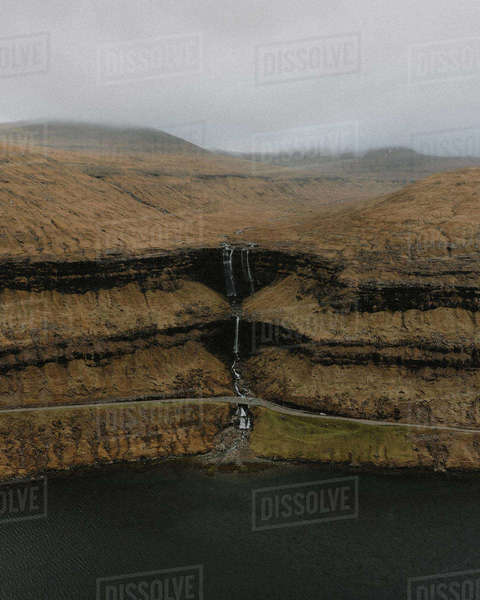 Three-tier waterfall flowing over cliff into sea, Fossa, Haldarsvik ...
