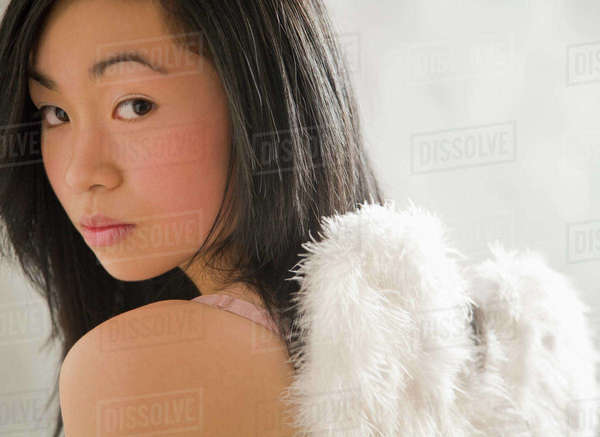 Close up of young woman with white feather wings - Stock Photo - Dissolve