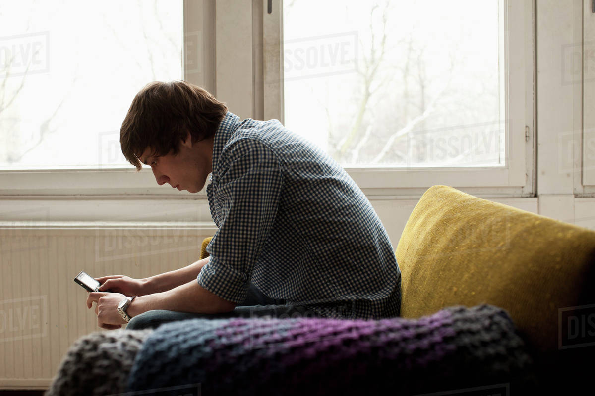 A teenage boy text messaging - Stock Photo - Dissolve