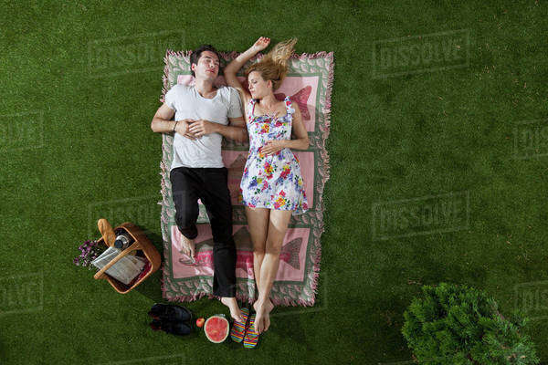 A couple napping on a blanket in a park, overhead view - Royalty-free ...