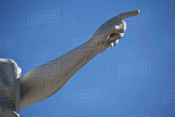 Statue pointing, blue sky background, close-up of arm - Stock Photo ...